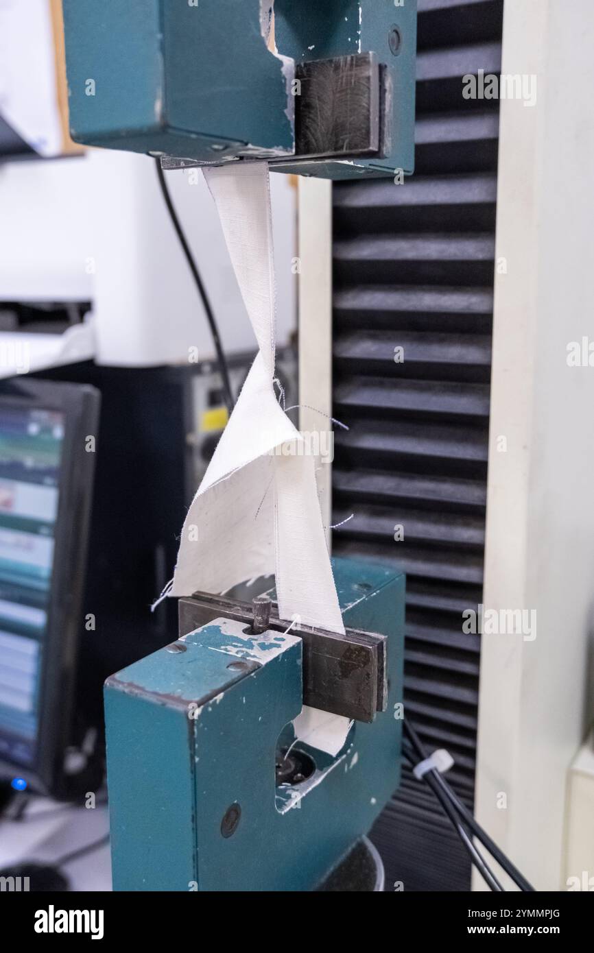 In close up view, the tearing strength test of a fabric in a textile ...