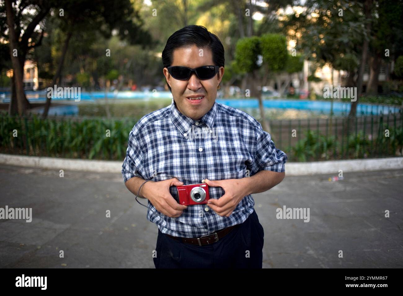 A blind student takes a picture during a photography workshop for the ...