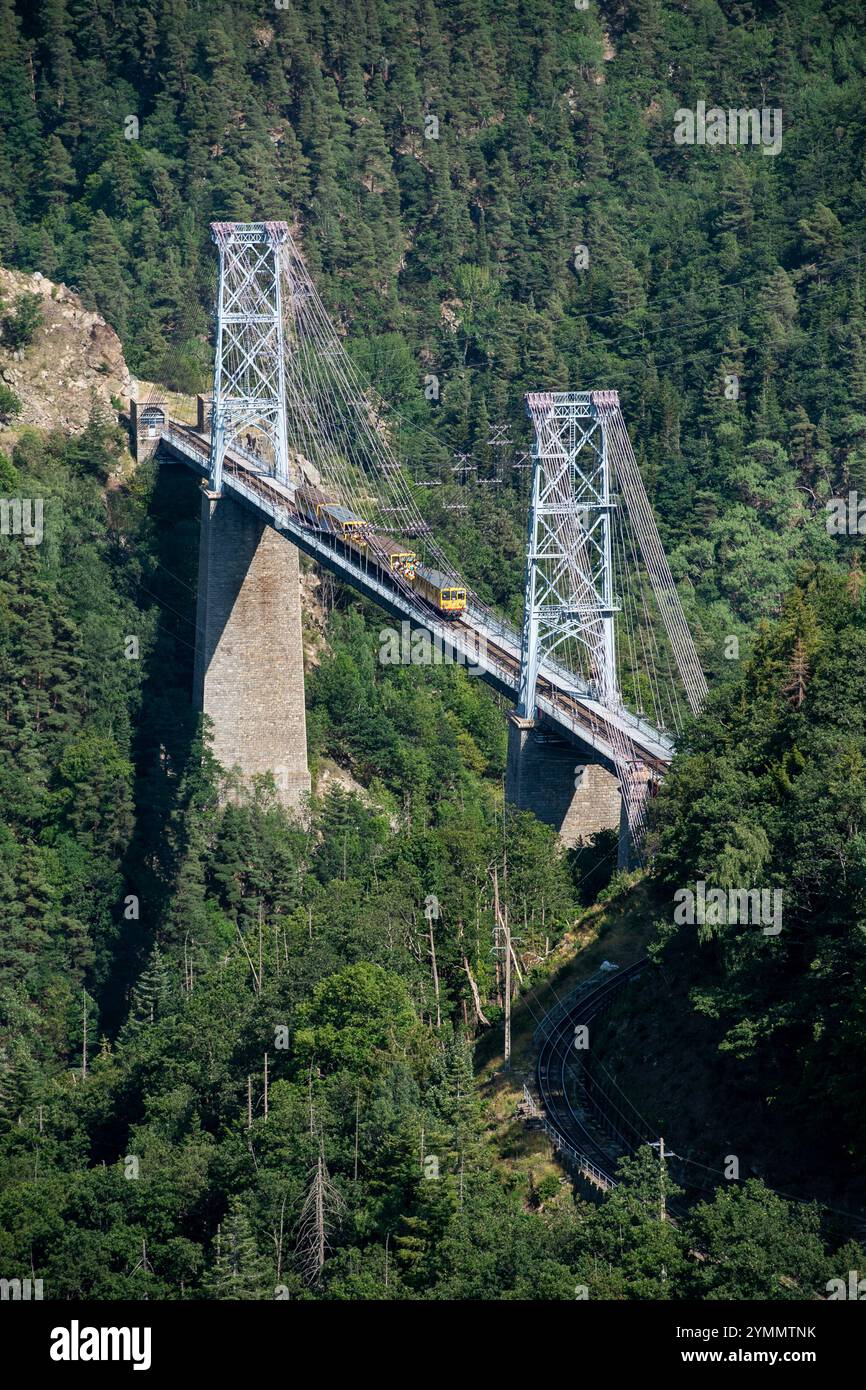Planès (south of France): yellow train on the suspension bridge “pont ...
