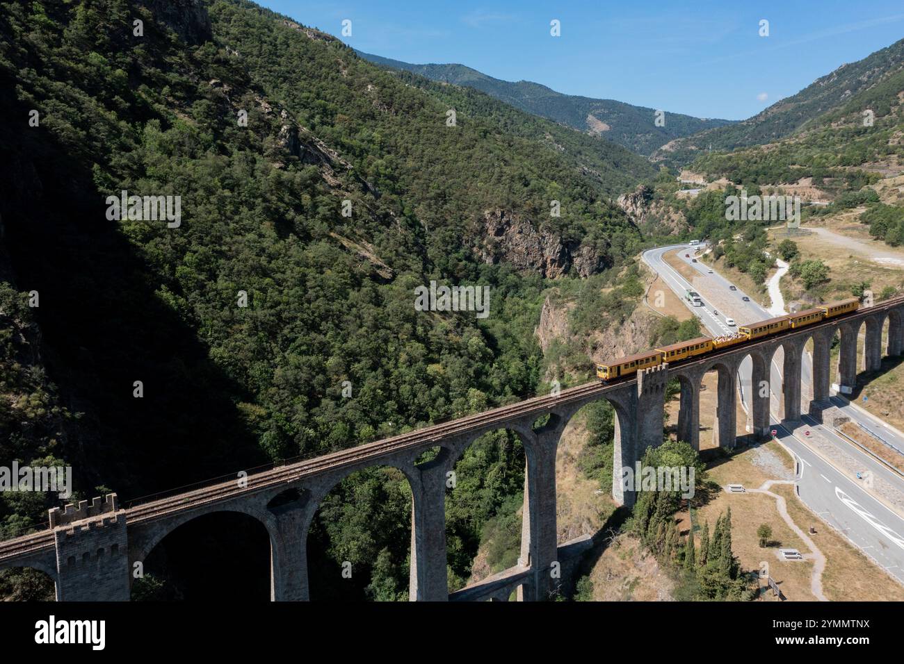 Fontpédrouse (south of France): yellow train on the railway arch bridge ...