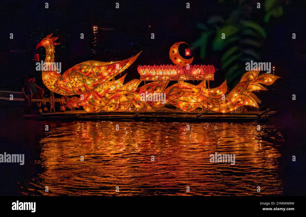 Traditional illuminated phoenix boat floating on water at night ...