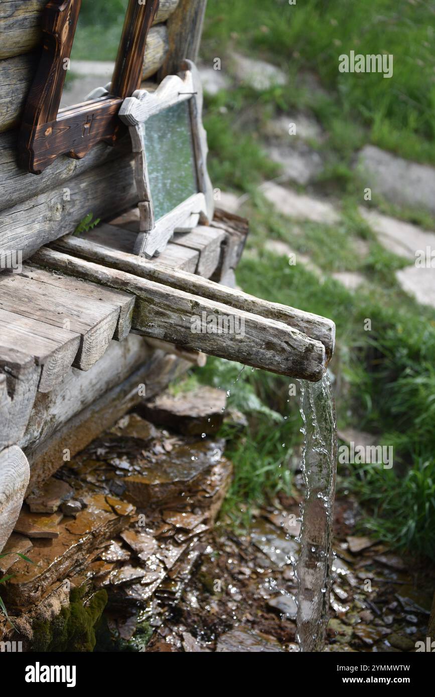 Rustic wooden water fountain flowing gently Stock Photo - Alamy