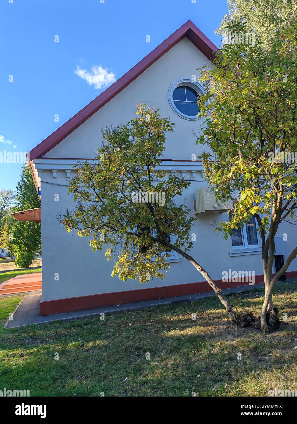 historic building with red brick columns and a sloping roof, nestled ...