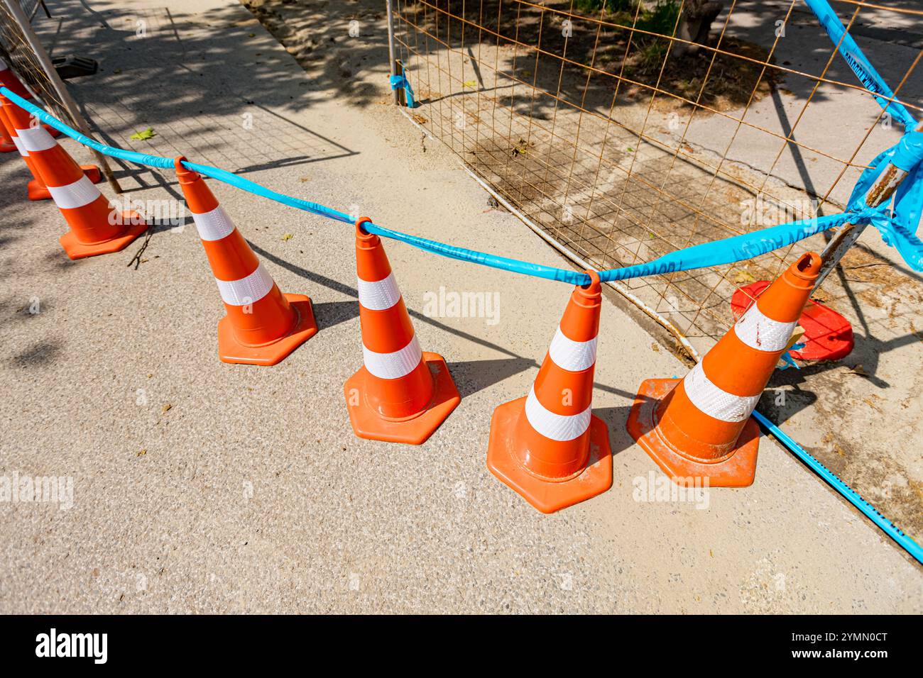 Several orange traffic cones with white fluorescent stripes are on the ...