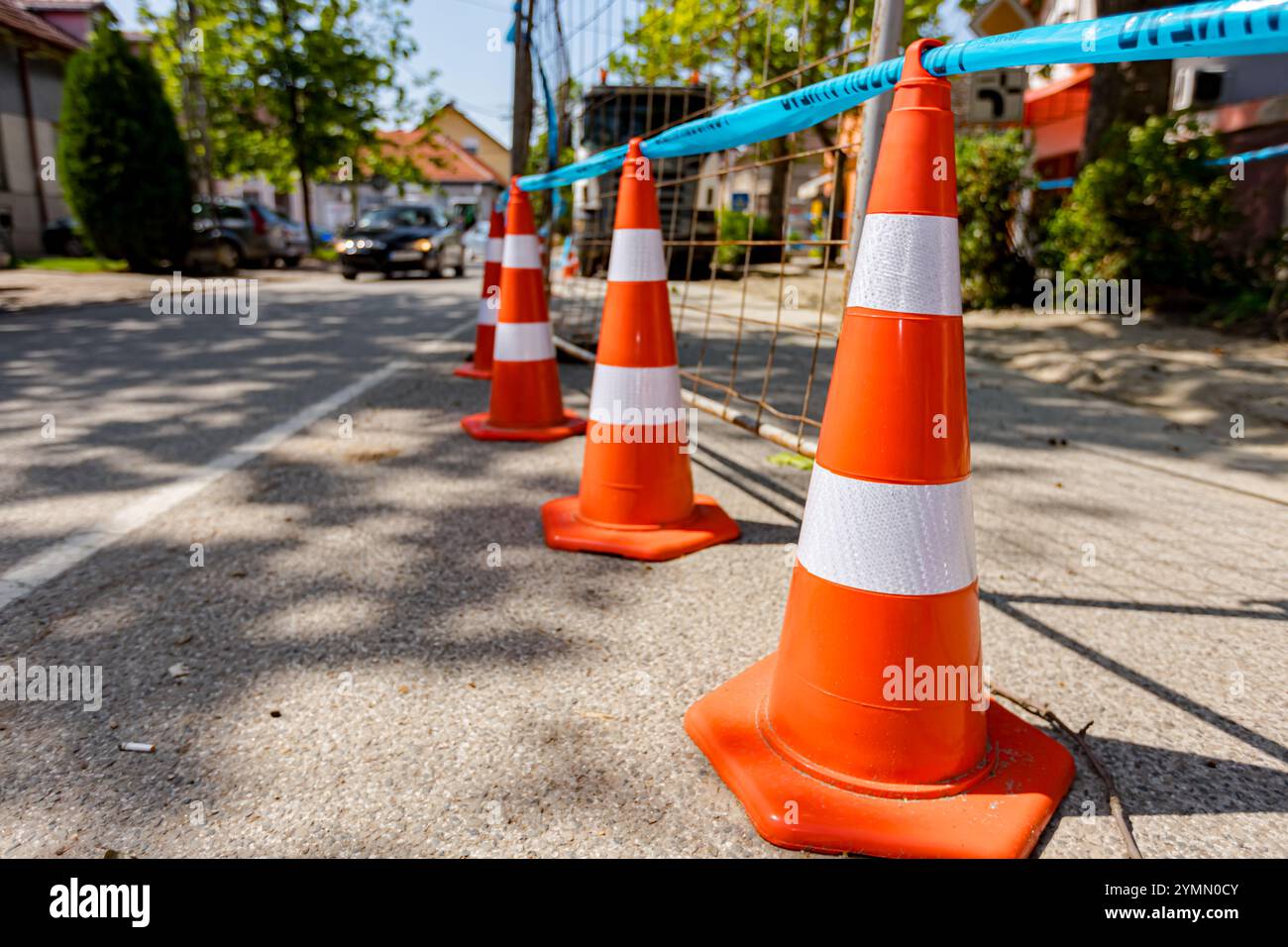 Several orange traffic cones with white fluorescent stripes are on the ...