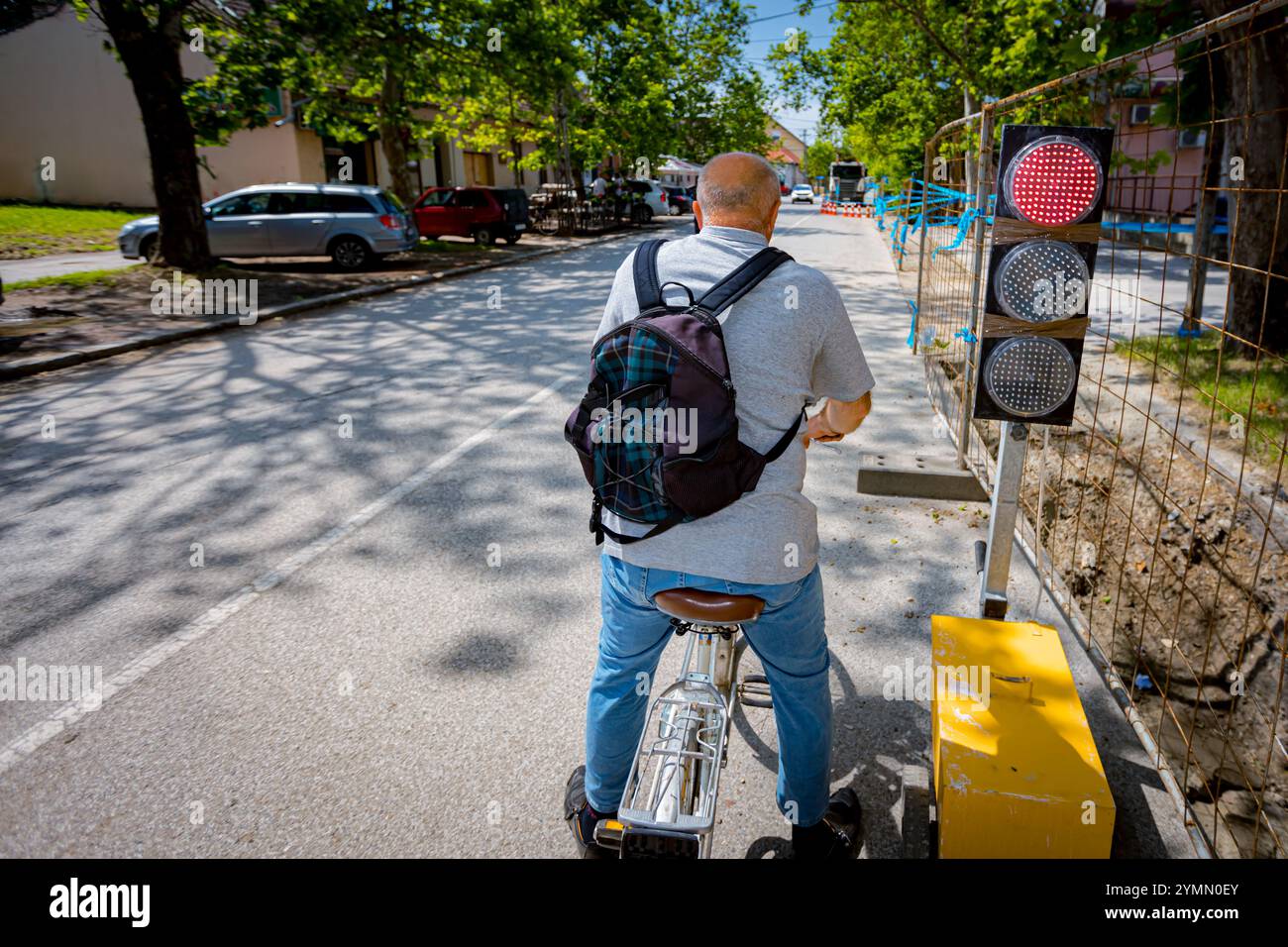 Cyclist is standing, waiting at red traffic light, semaphore Stock ...