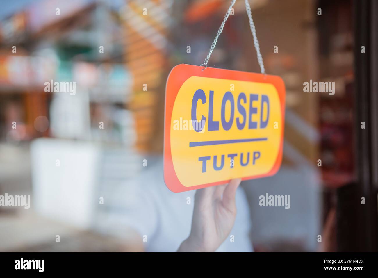 Closeup portrait of an employee flipping closed sign Stock Photo - Alamy