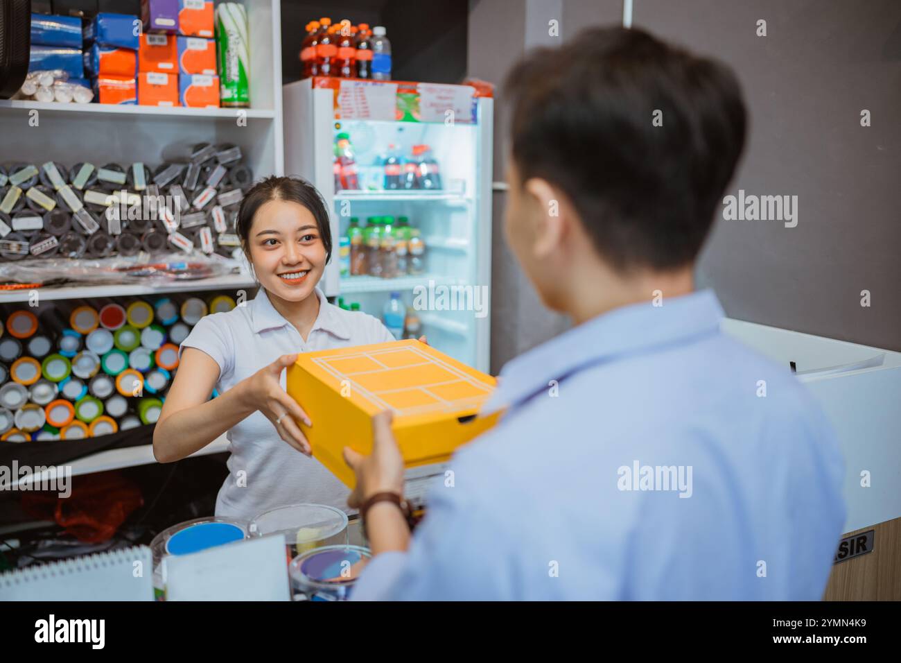 female staff hand over product male customer Stock Photo - Alamy