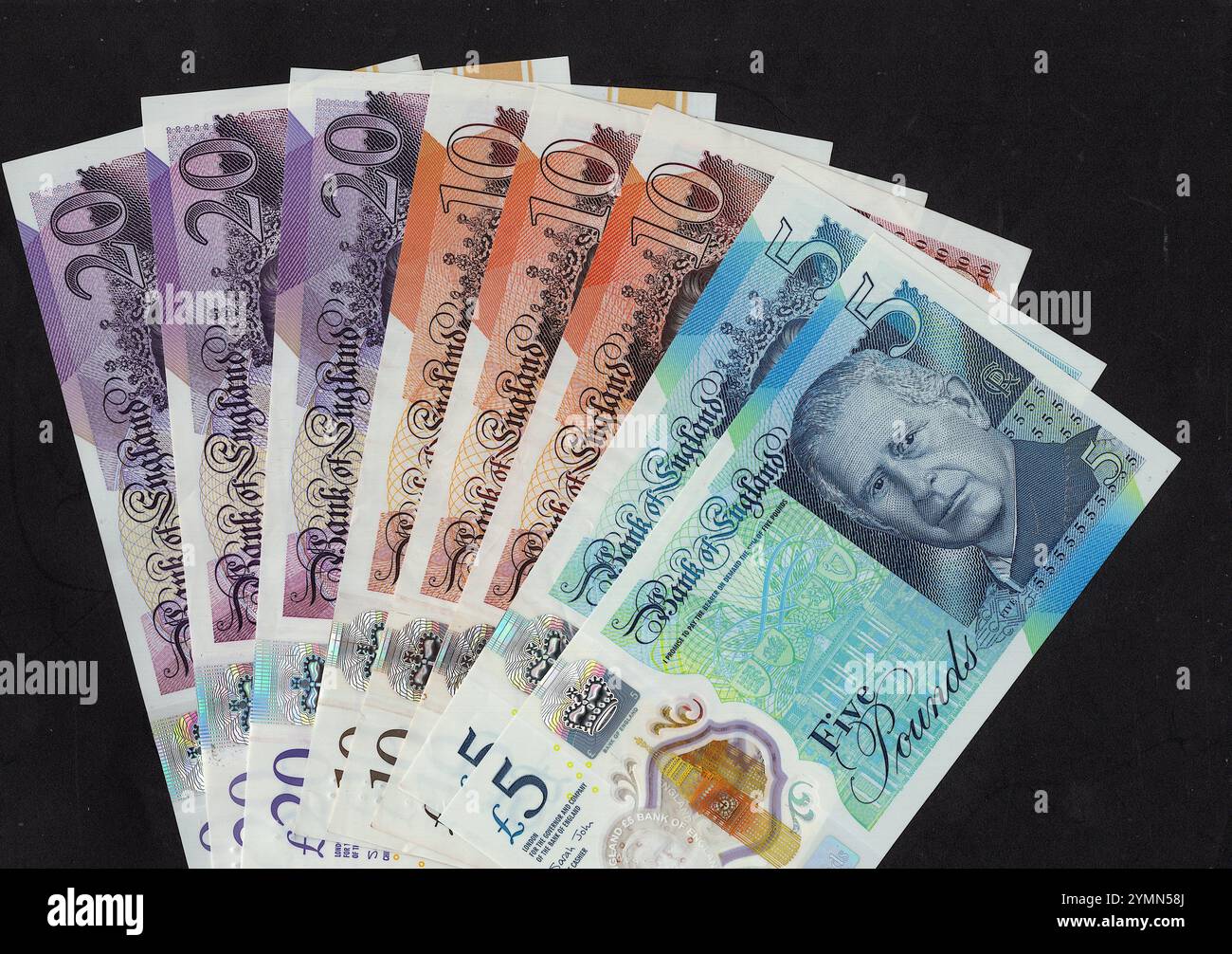 A King Charles III £5 banknote from the United Kingdom in a fan of ...