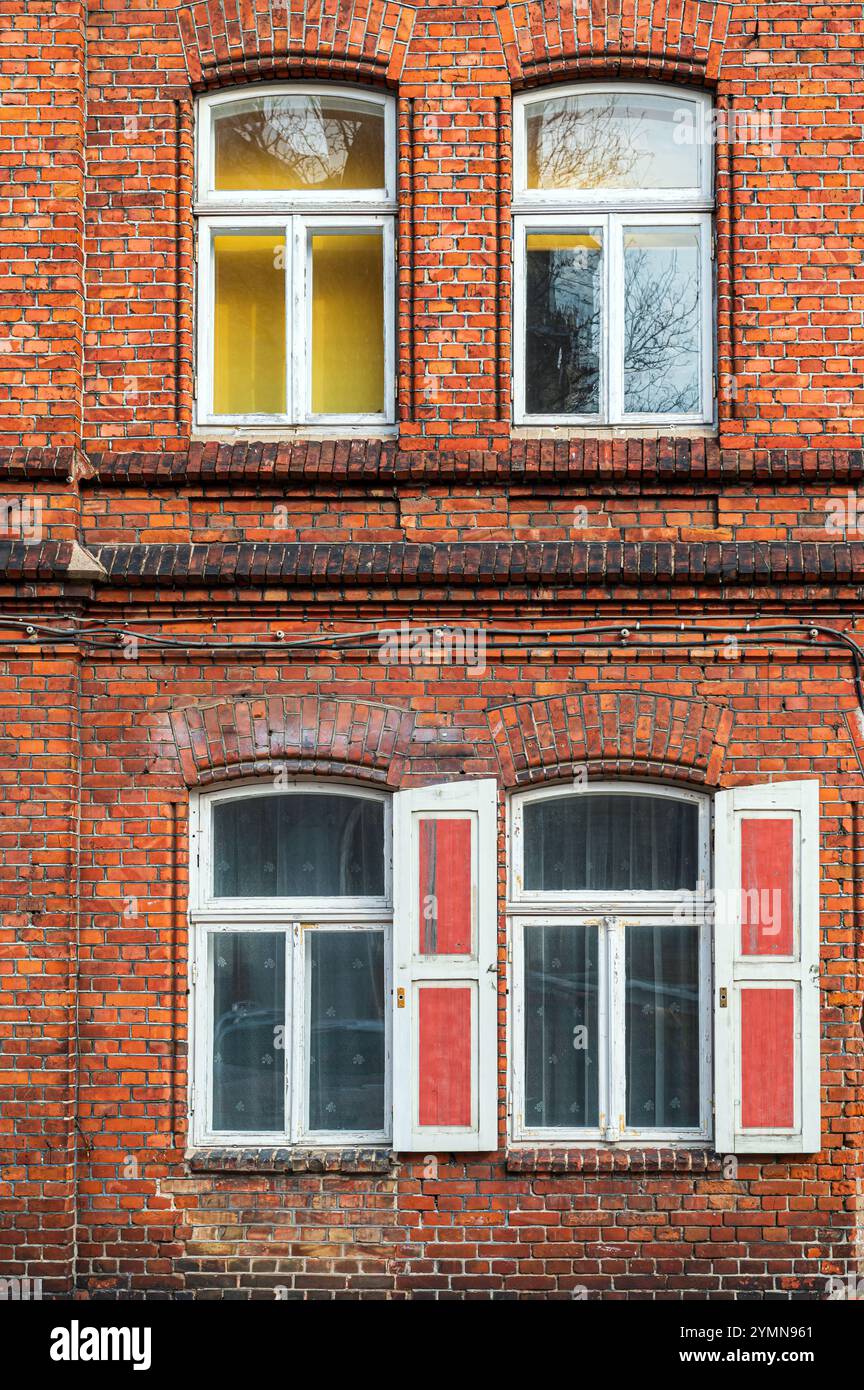 A red brick building showcases white window frames with shutters wide ...