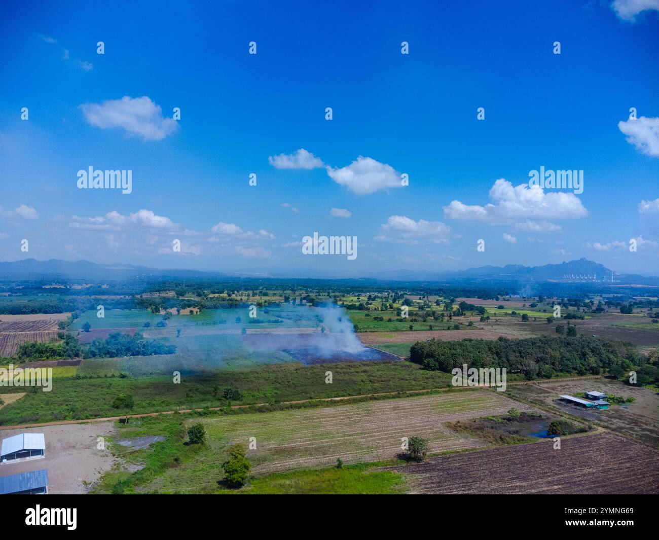 Aerial view of farmers burning corn residue after harvest. Corn field ...