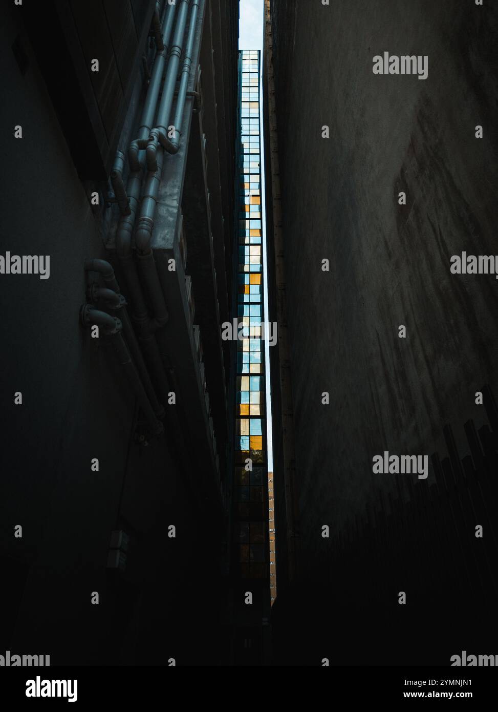 Narrow Alley Framing a Colorful Glass Facade with Exposed Pipes and ...