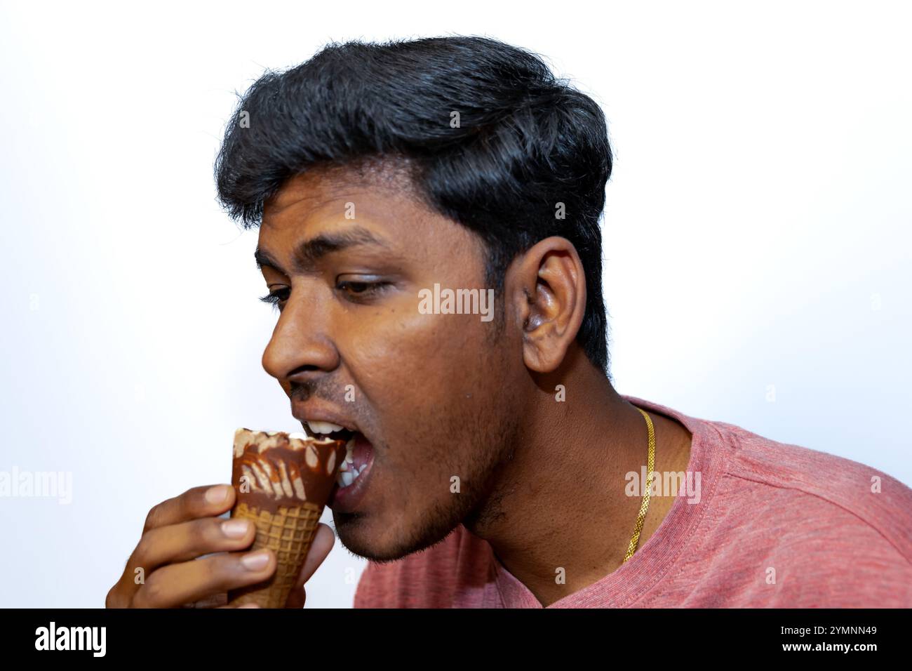 Young man savoring a delicious chocolate-dipped ice cream cone. A sweet ...