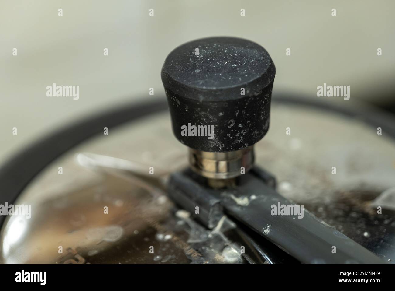 Close-up of a well-used pressure cooker valve, showing signs of wear ...