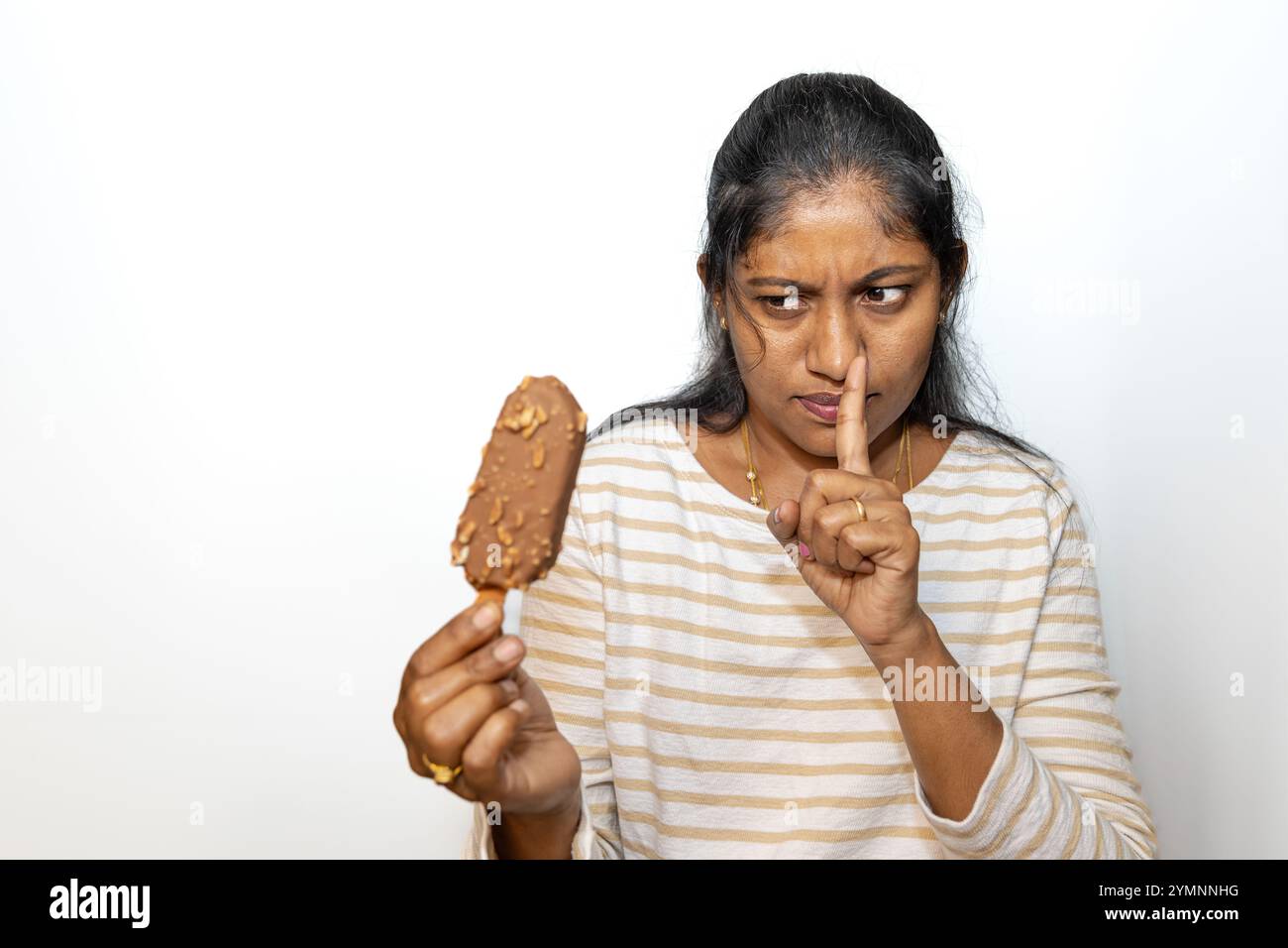 Shh! It's my secret indulgence. Woman savoring a delicious chocolate ...