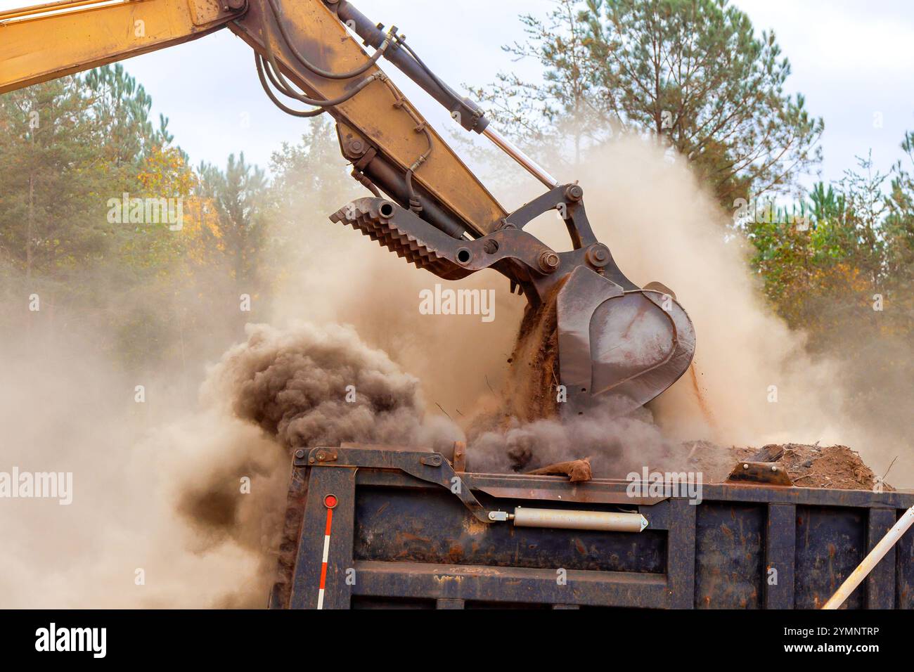 An excavator is to process move earth into dump truck at construction ...