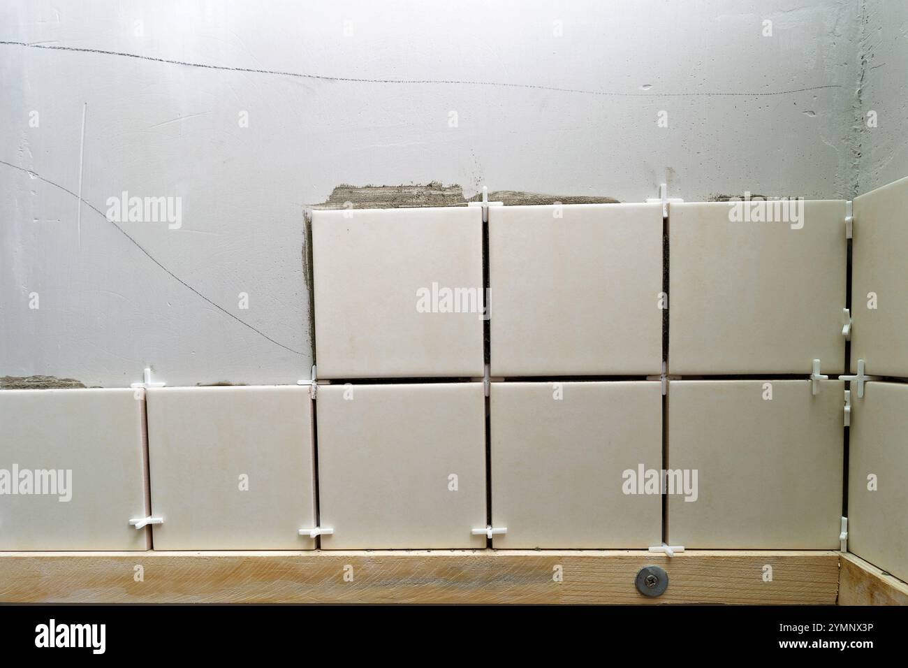 Start of laying ceramic tiles on the wall. Laying on crosses Stock ...