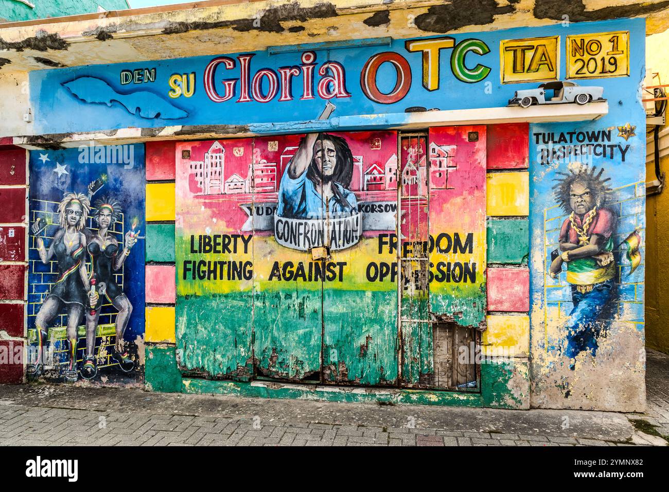 A boarded-up storefront serves as a canvas for changing murals. The ...