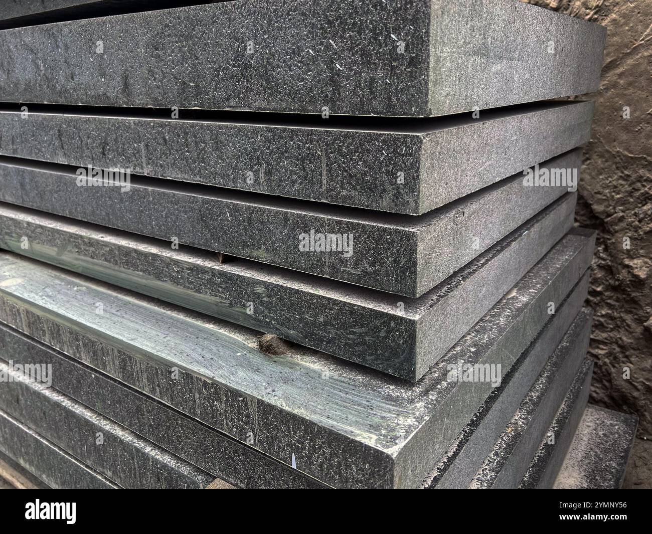 Granite slabs stand in rows. Granite slabs for tombstones. Workshop for ...