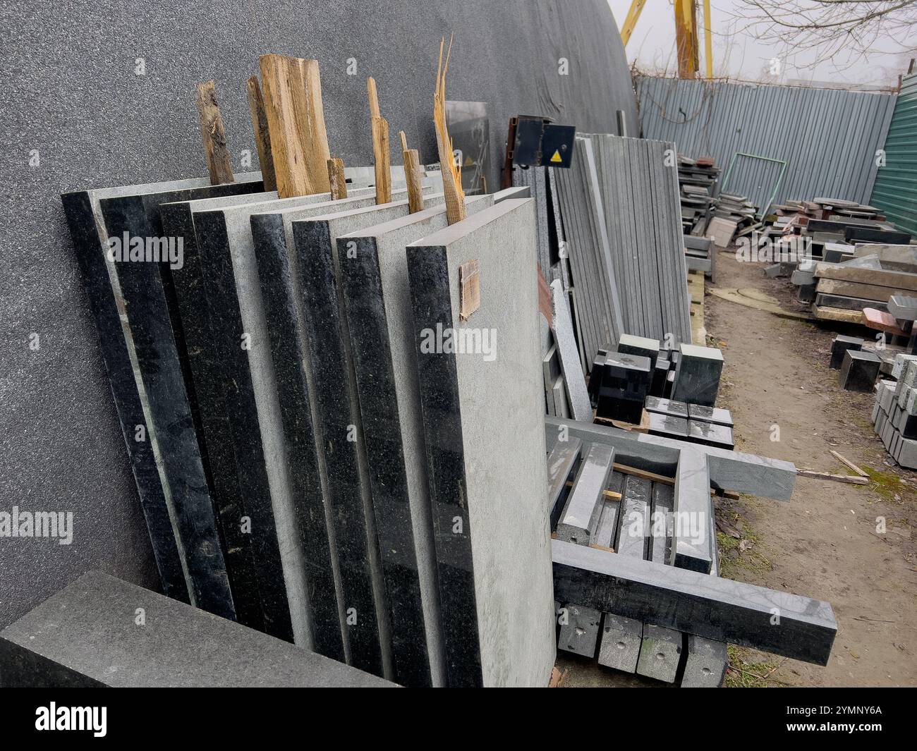 Granite slabs stand in rows. Granite slabs for tombstones. Workshop for ...