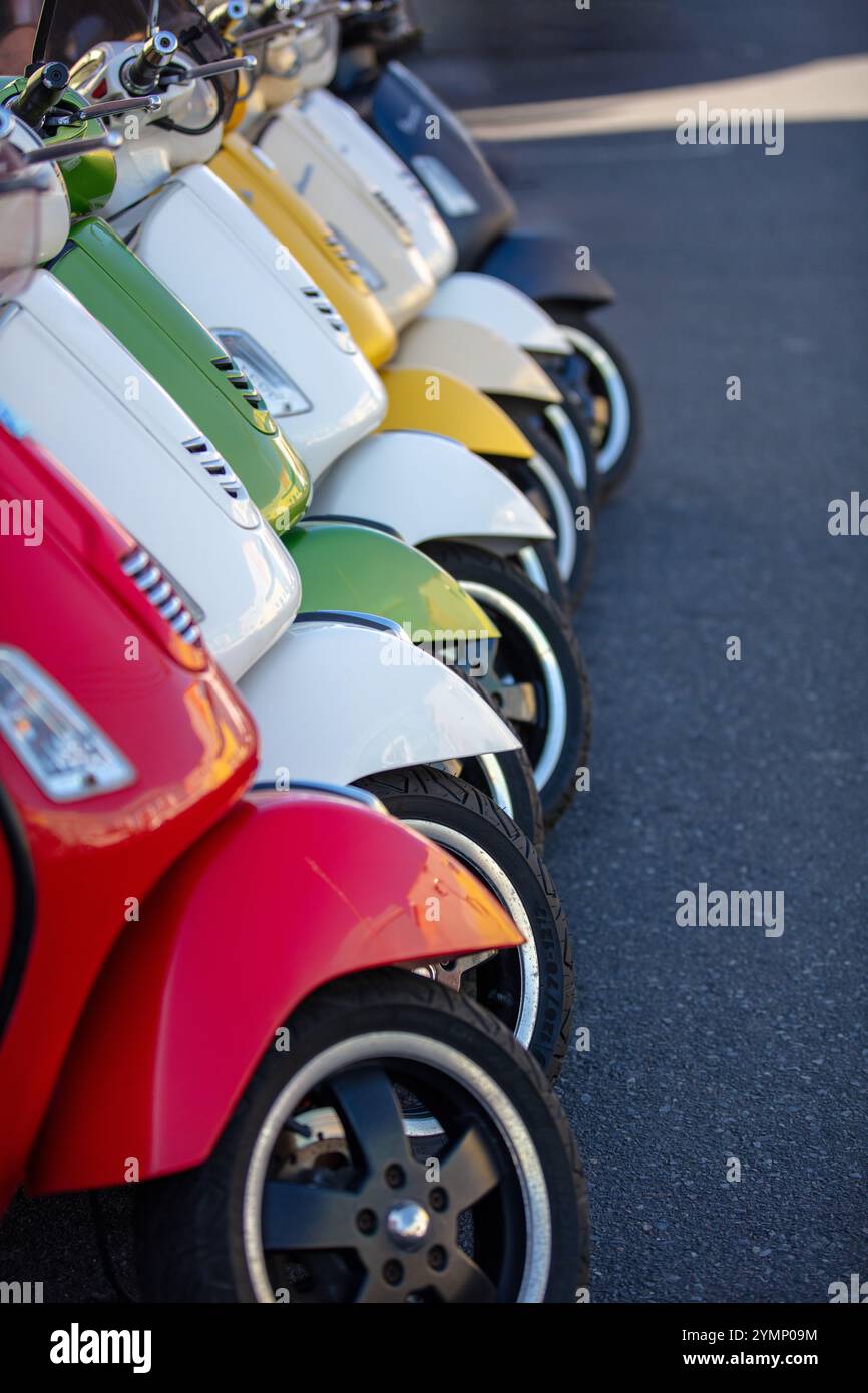 New retro motor scooters parked side by side on a street. Vibrant ...