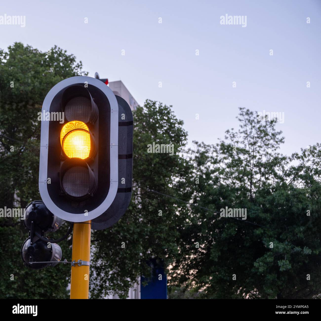 Amber color traffic light for cars at the city center. Orange semaphore ...