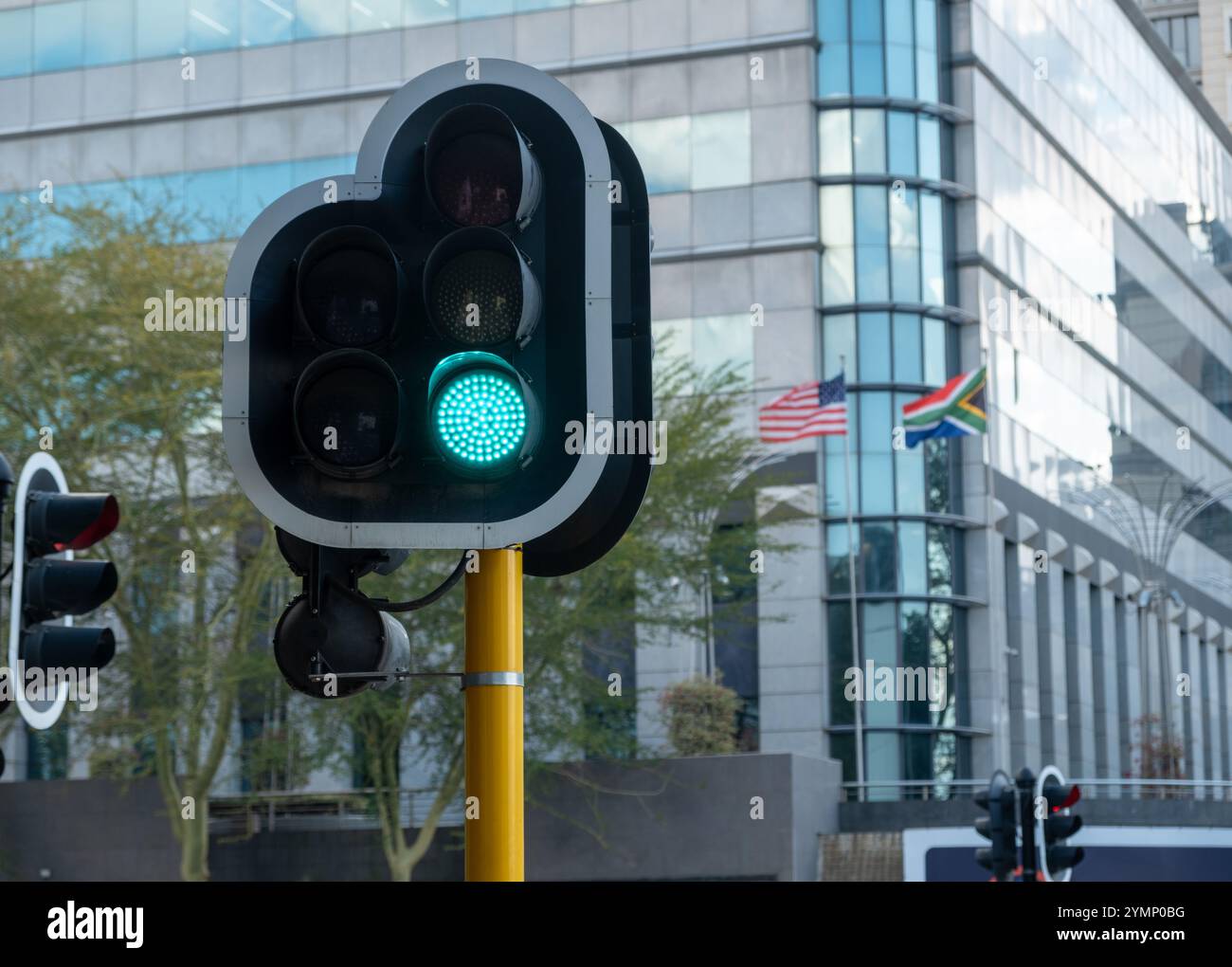 Green traffic light at the city center. Go straight signal. Office ...