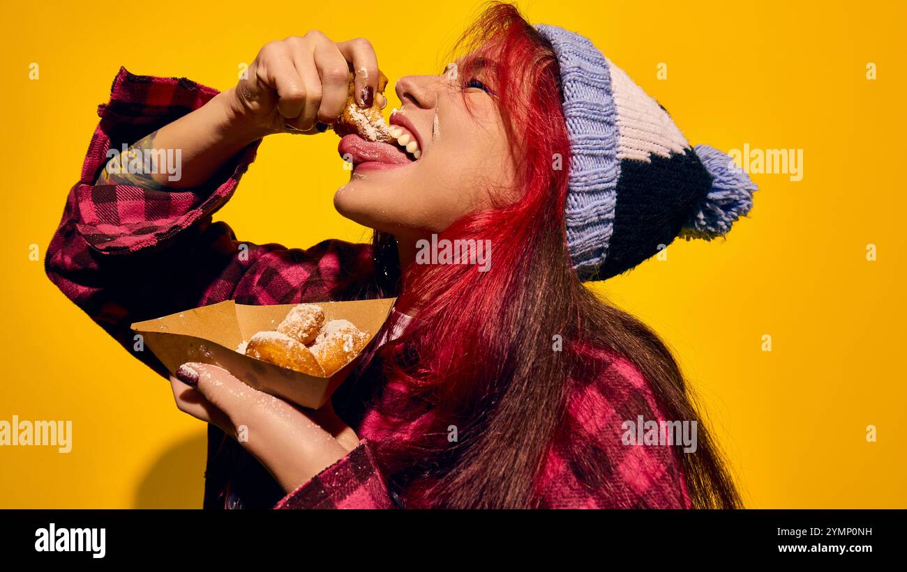 Side view portrait of happy young redhead woman in knitted hat eating ...