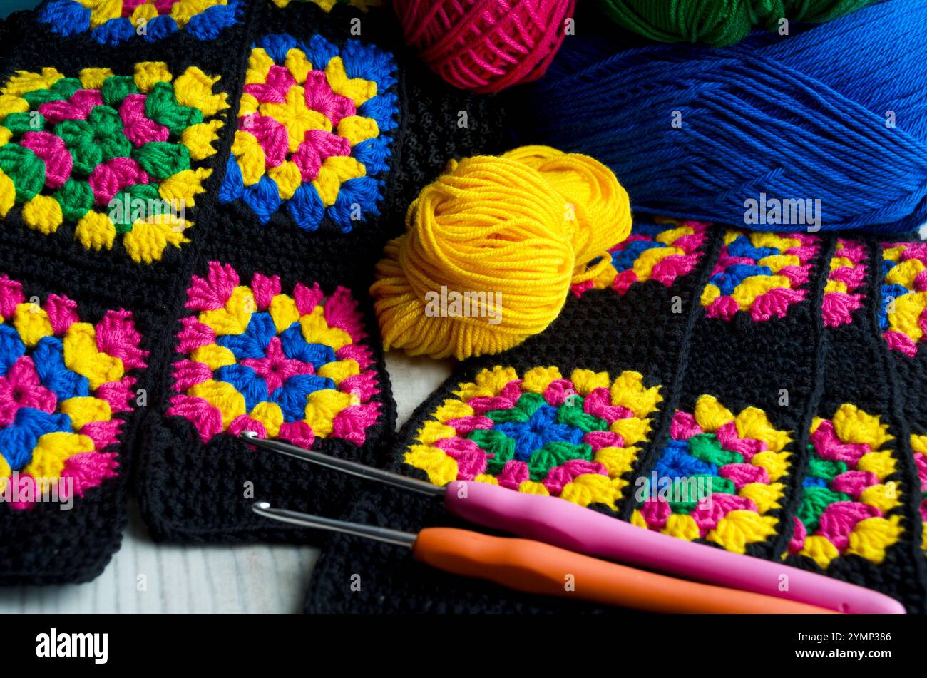 Crochet texture, thread rolls and hooks. Colorful cotton granny square ...