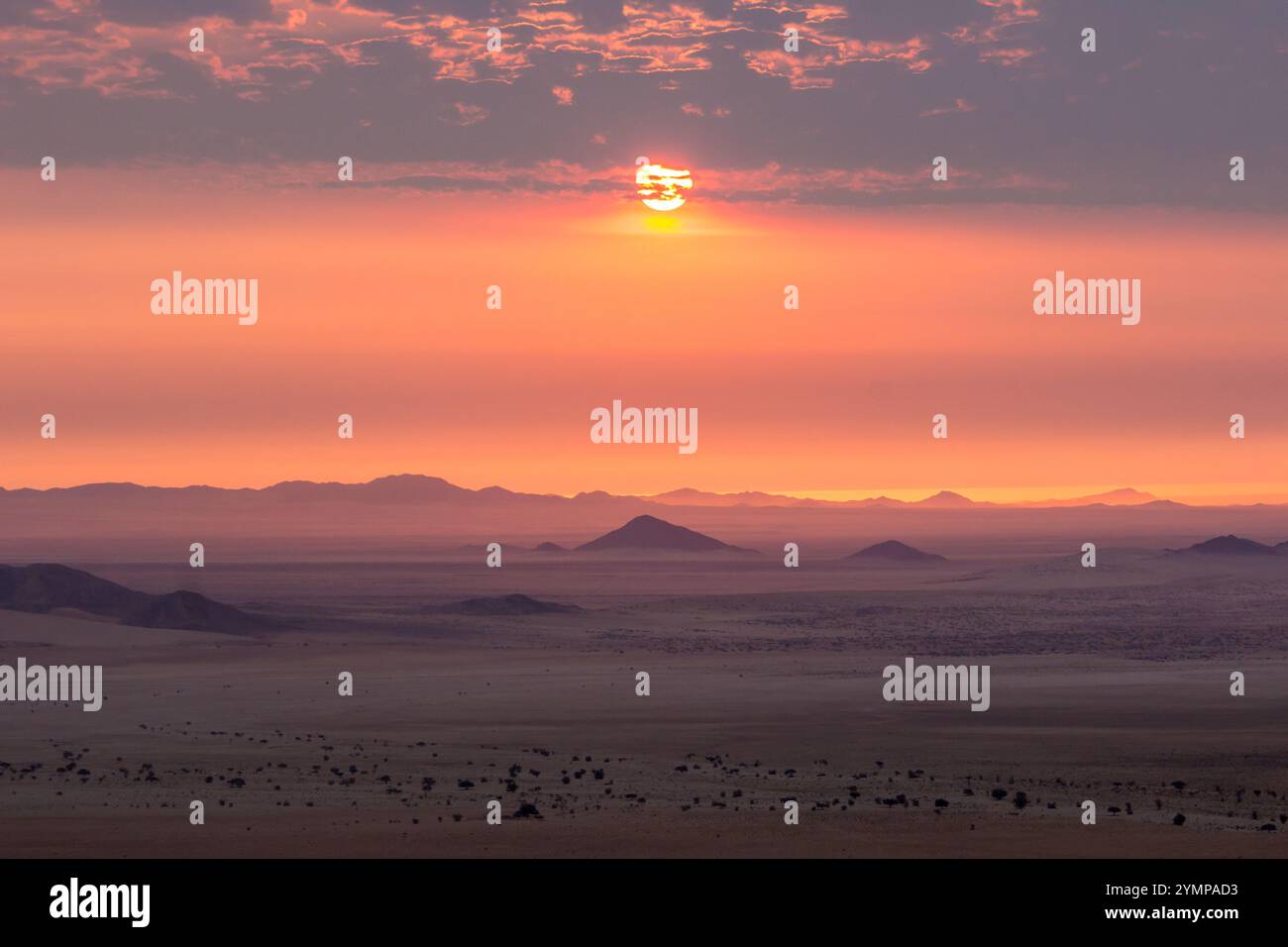 The setting sun breaking through the high stratus cumulus clouds over ...