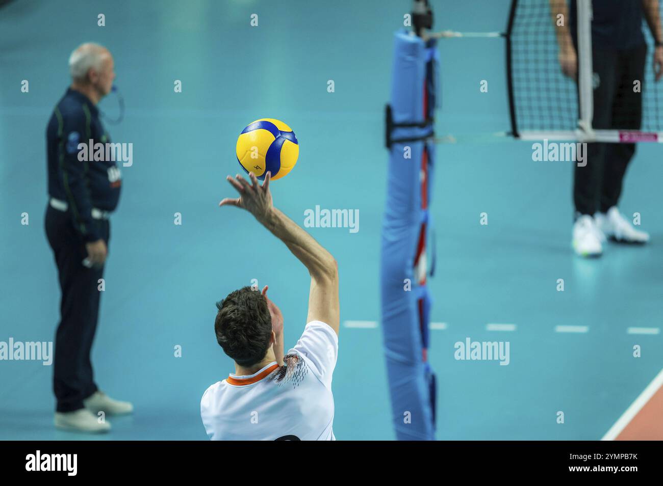 Volleyball player sreves ball, referee in the background Stock Photo ...