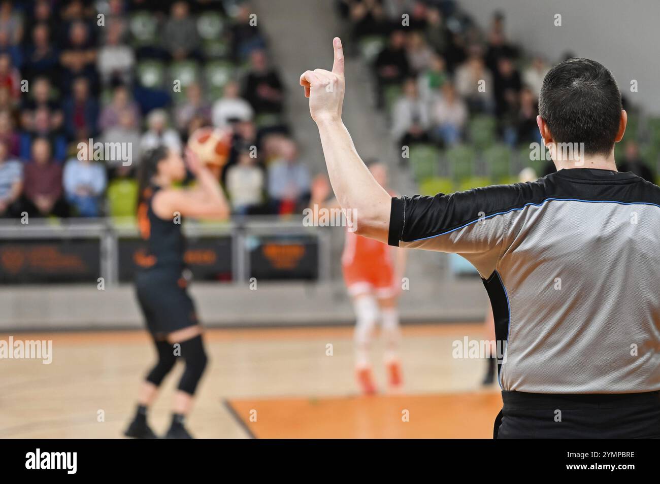 Man referee shows the free throw with his hands. In the background ...