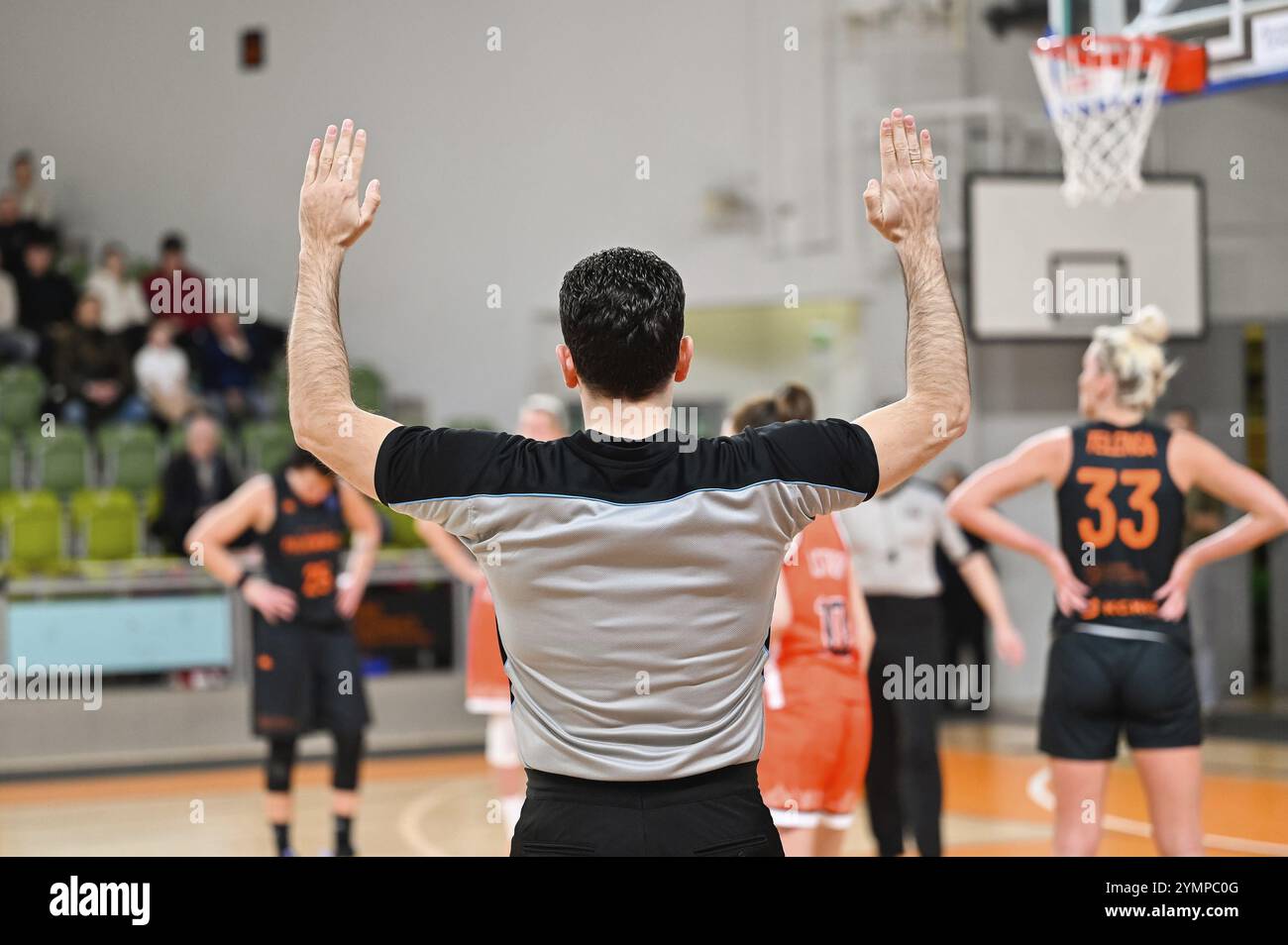 Man referee shows the free throw with his hands. In the background ...