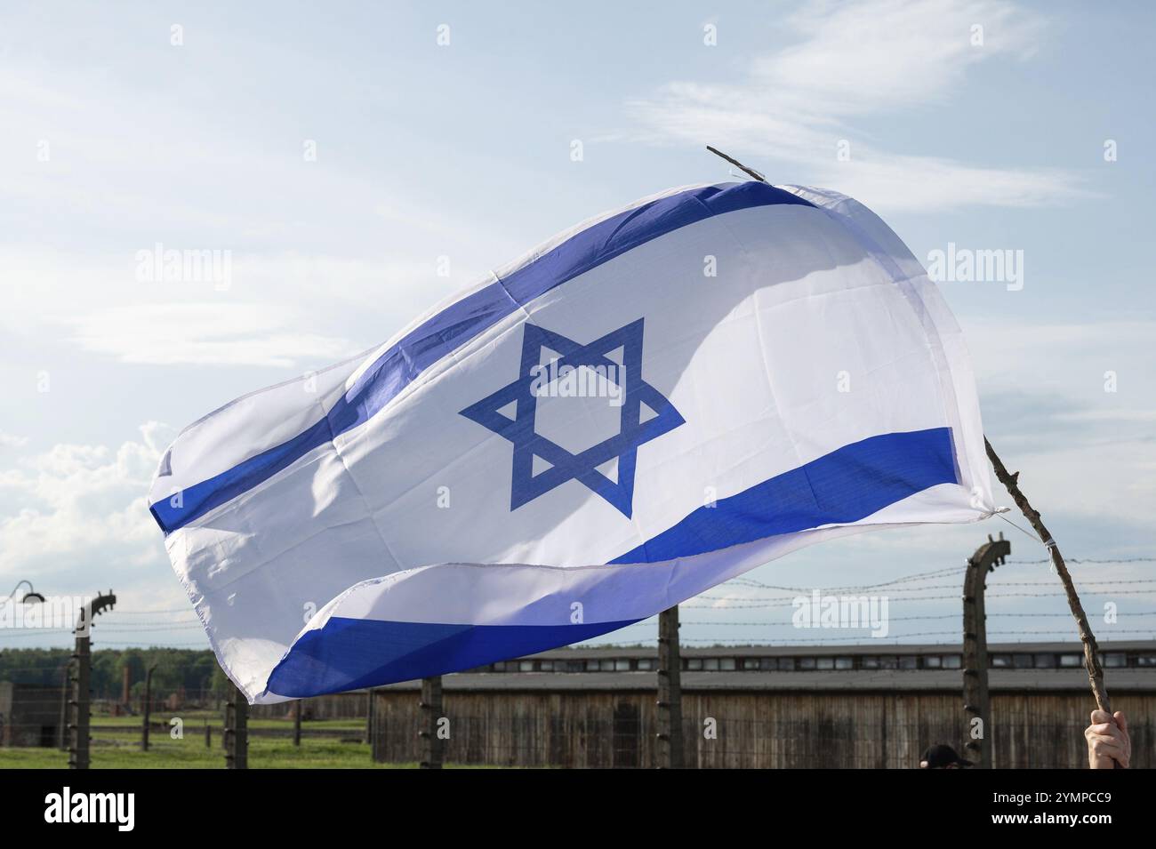 The flag of Israel in the background barbed wire fence of a ...