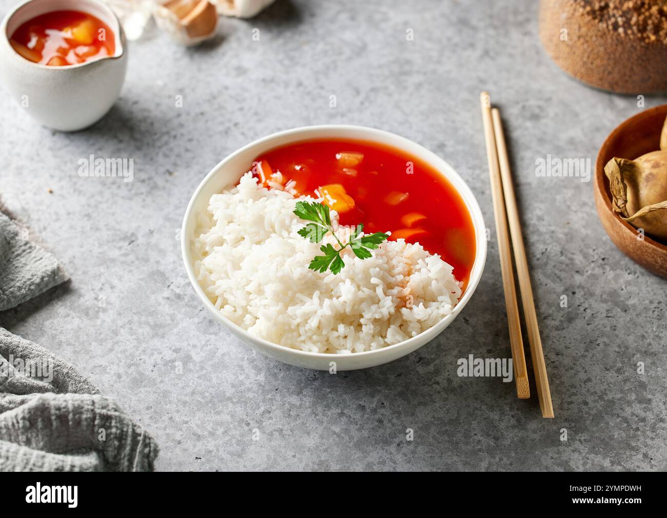 bowl of boiled basmati rice with sweet and sour sauce on grey kitchen ...