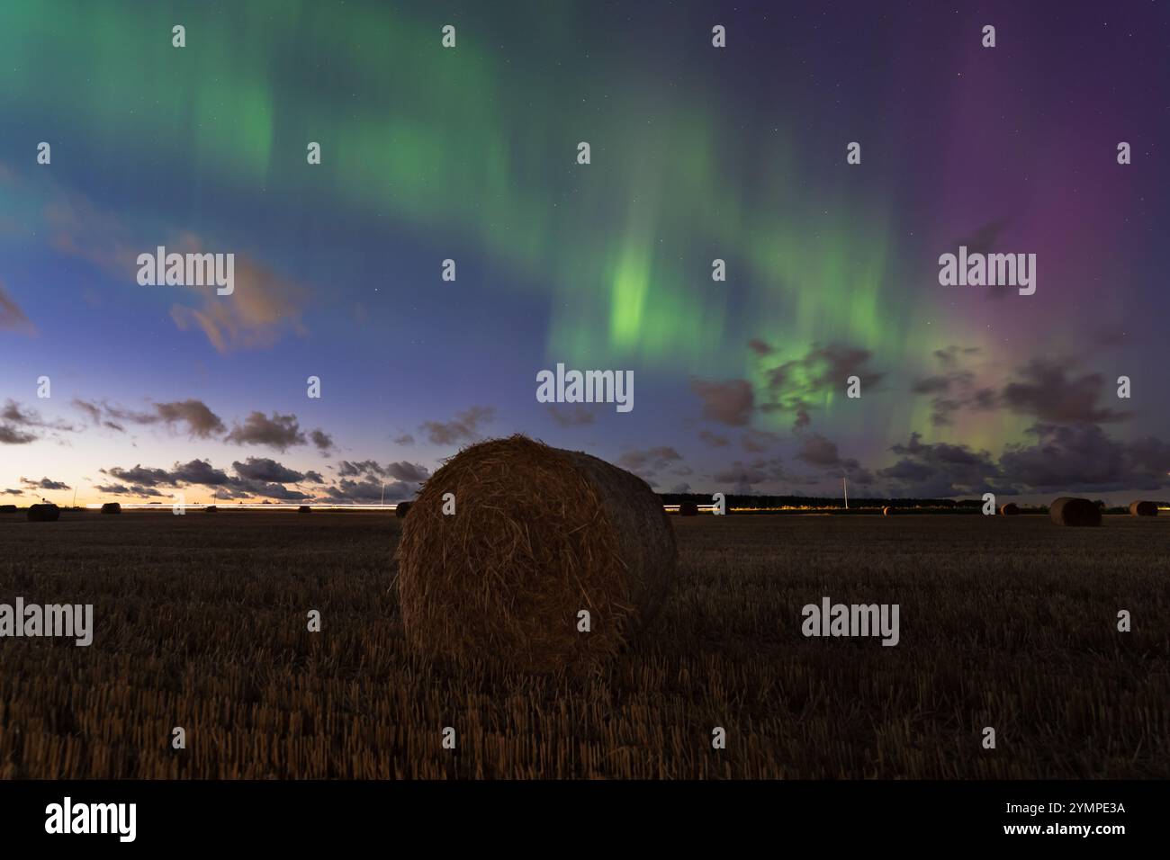 Night landscape, nature of Estonia. A sheaves of hay on a field, starry ...
