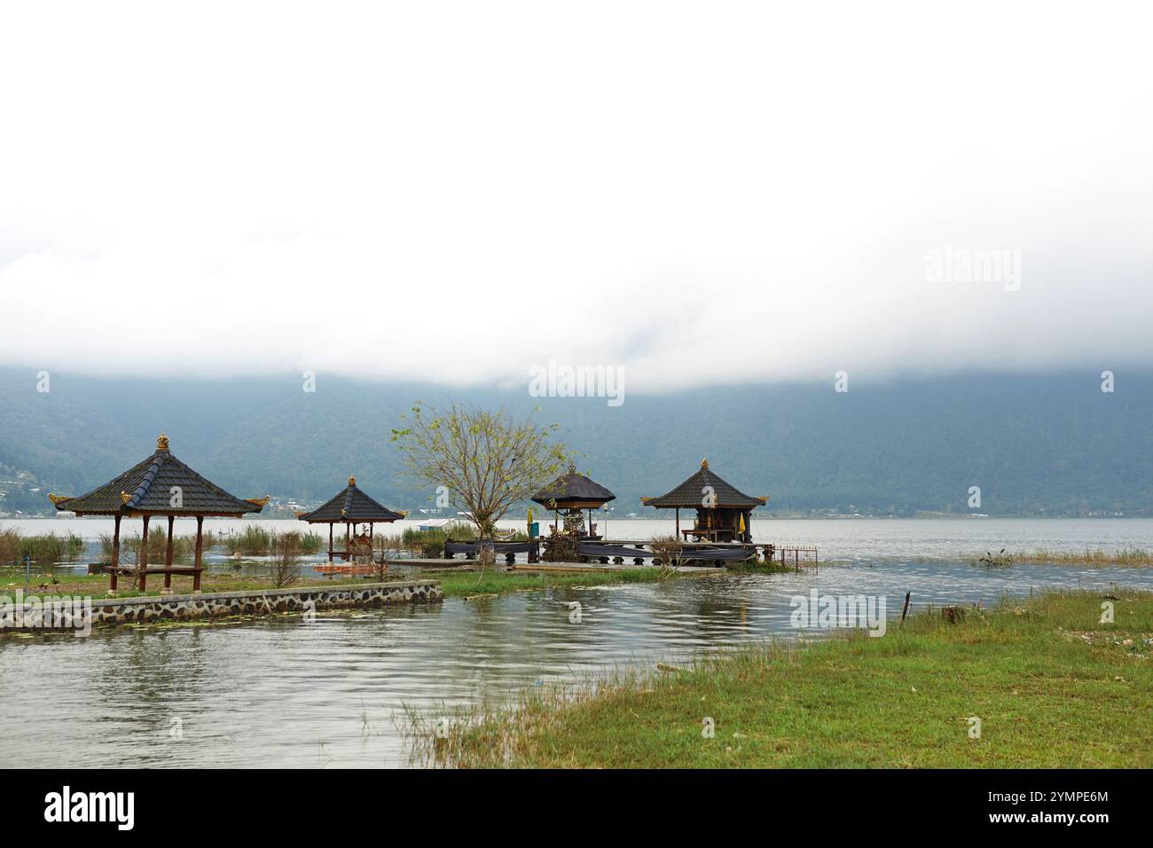 Traditional gazebos on the Bratan mountain lake in cloudy weather on ...