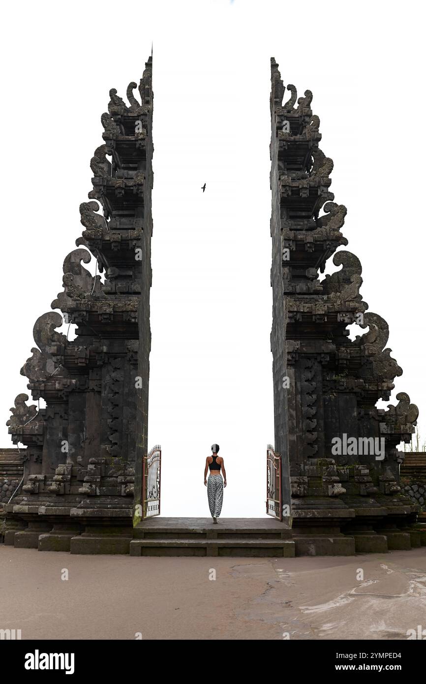 A woman stands at the Balinese traditional gate in the clouds at the ...