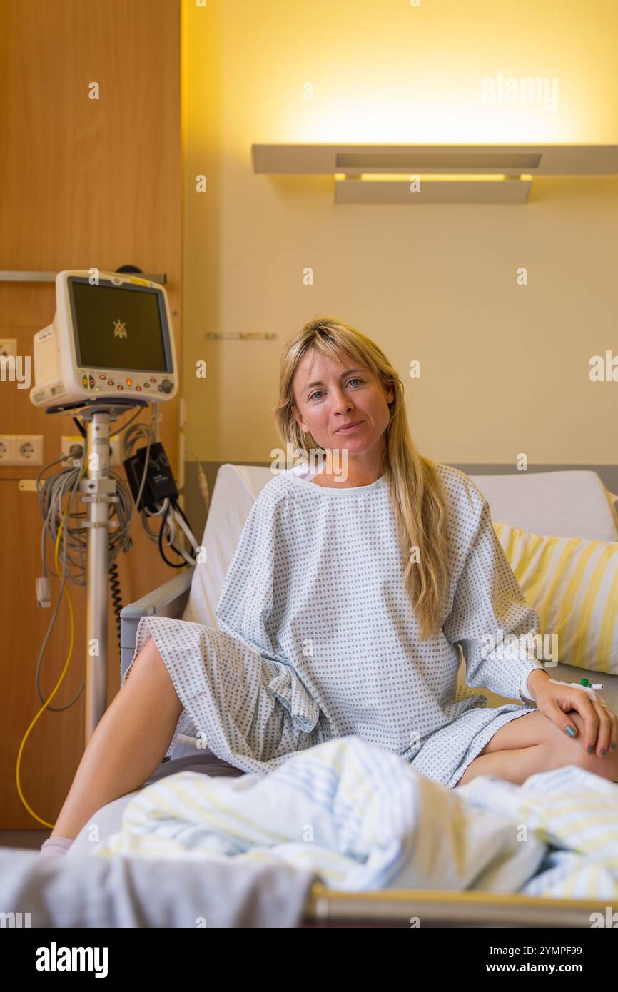 Pretty young female patient in a modern hospital room after surgery on ...
