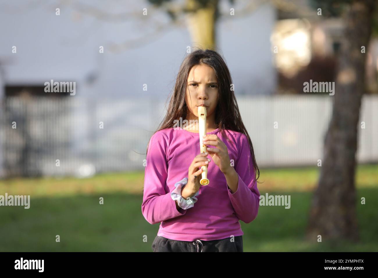Little girl playing a recorder flute in the garden Stock Photo - Alamy