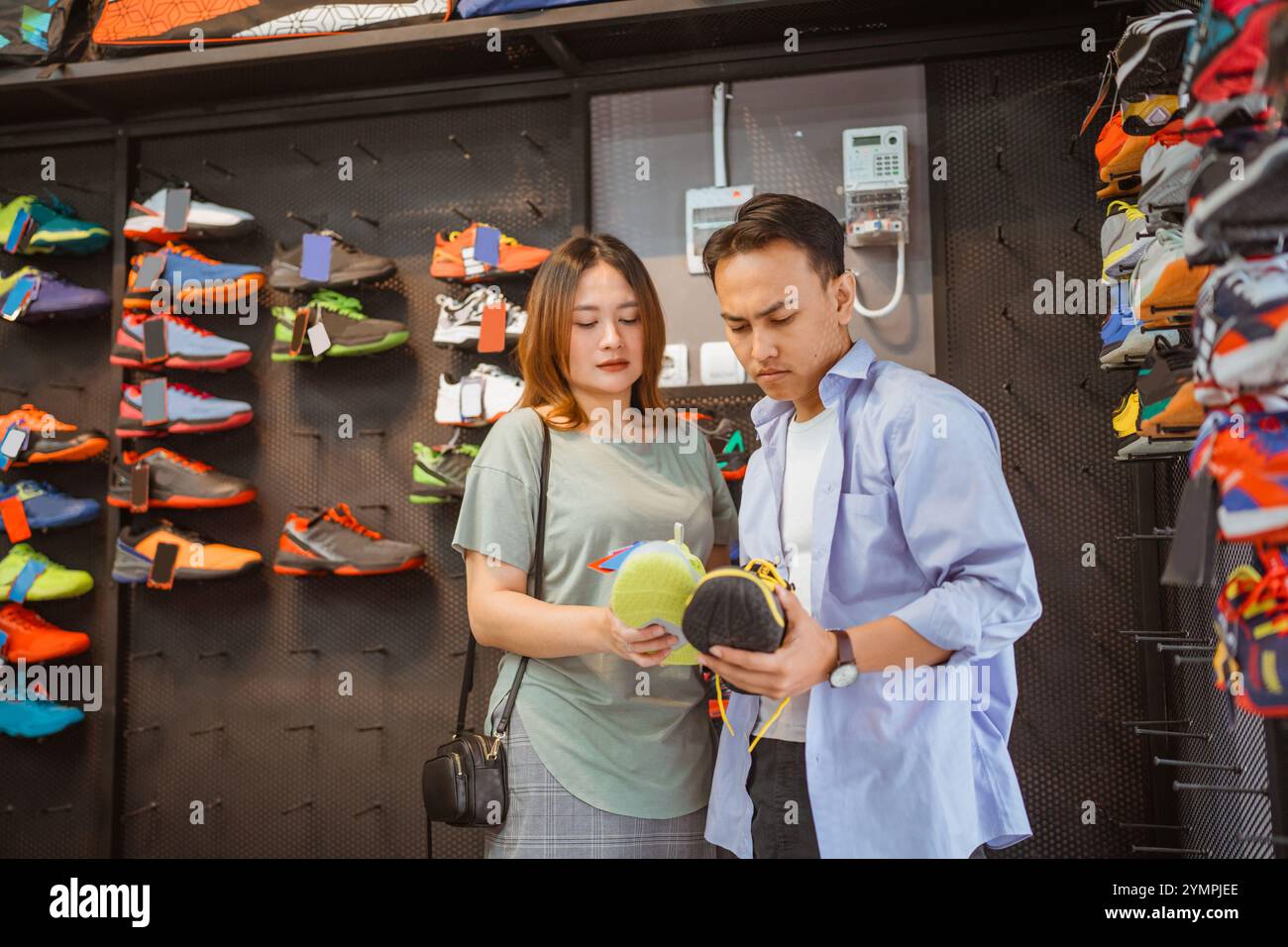 male customer confused comparing athletic shoe Stock Photo - Alamy
