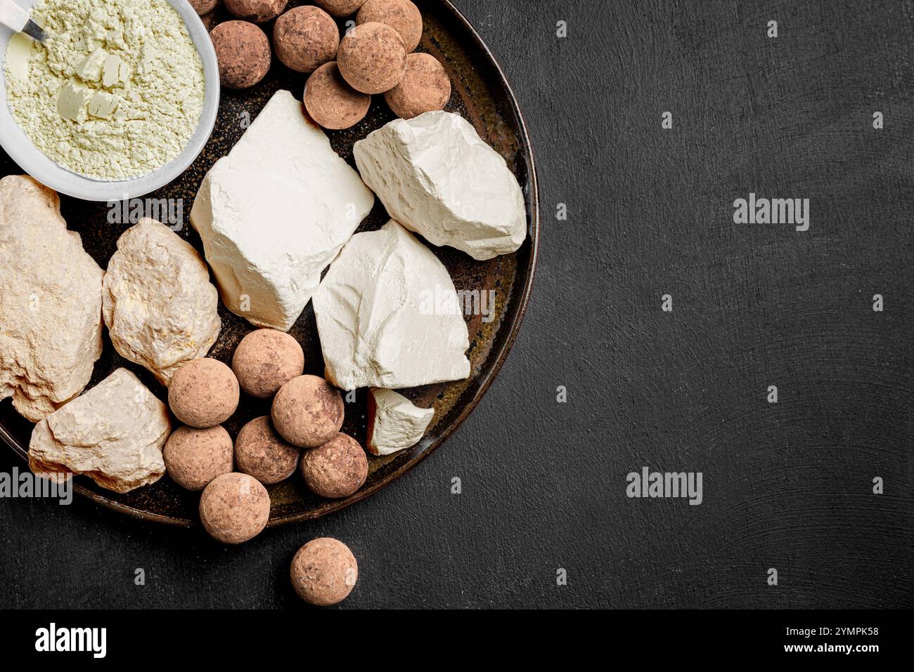 Edible caramel Clay Stones, clay rocks and powder on black background ...