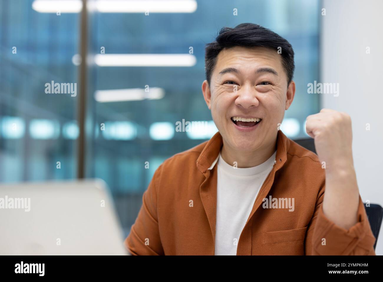 Asian man businessman expresses joy and success in office. His smile ...