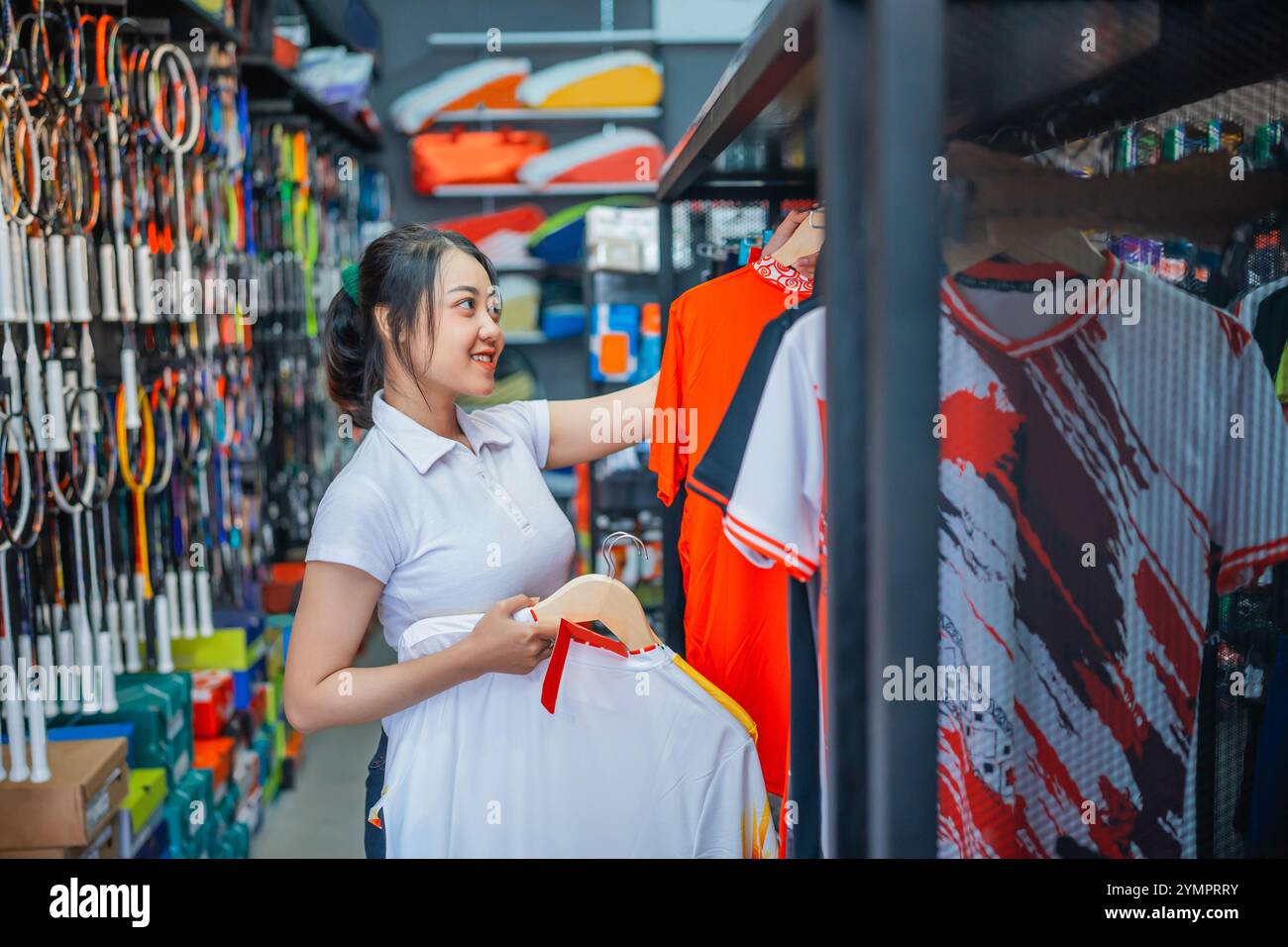 female staff hanging sports apparel rack Stock Photo - Alamy
