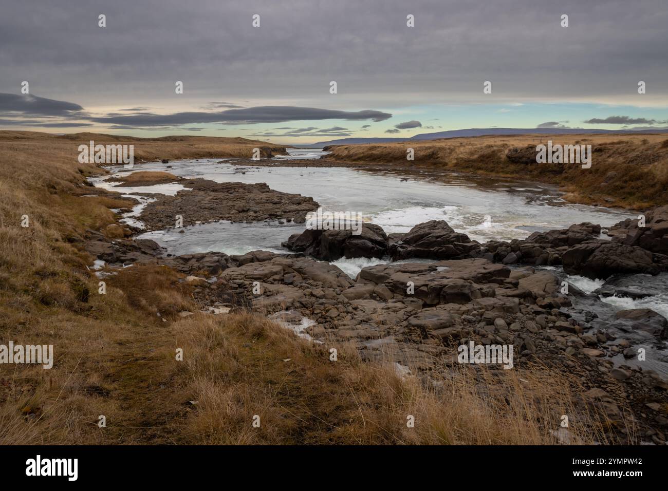 Low river in the autumn, with visible stones and rocks, surrounded by ...