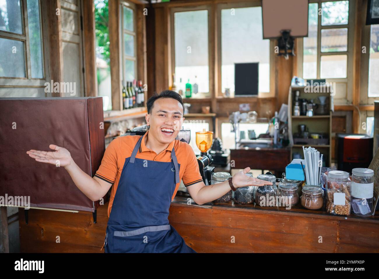 male coffee shop waiter with open arm gesture Stock Photo - Alamy