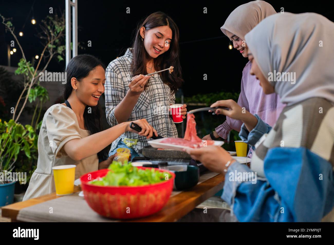 Friends Enjoying a Night Outdoor Dinner with Delicious Food and Great ...