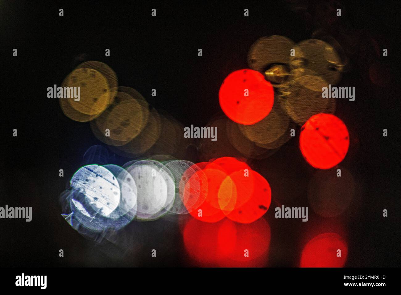 reflections of red brake lights from a car windshield in heavy rain and ...