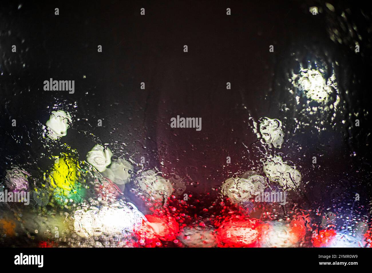reflections of lights from a car windshield in the rain in a traffic ...