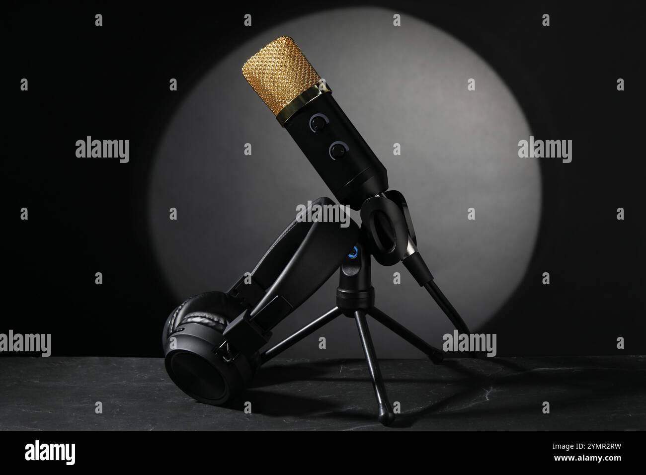 Stand with microphone and headphones on grey textured table. Sound ...